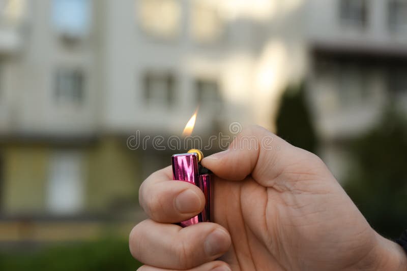 Man Holding Lighter with Burning Flame Outdoors, Closeup Stock Photo ...