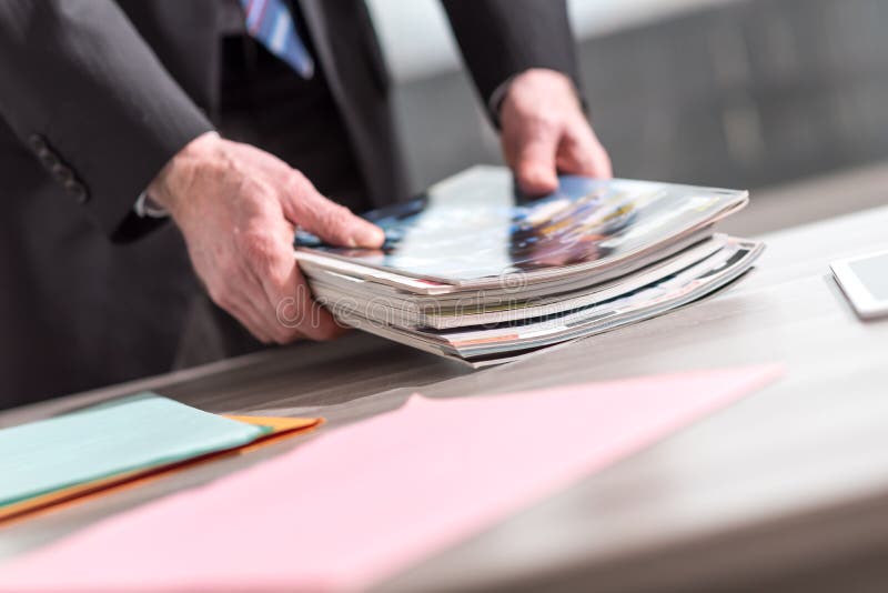 Man holding magazines stock image. Image of newspaper - 141301125