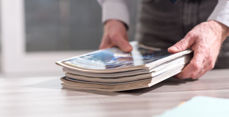 Man holding magazines stock photo. Image of publication - 142605728