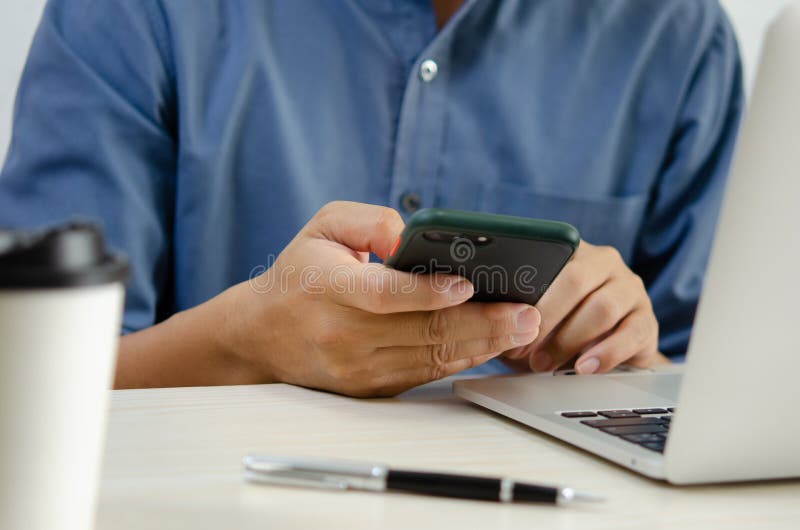 Man Holding Mobile Smartphone on Table with Computer Laptop Stock Photo ...