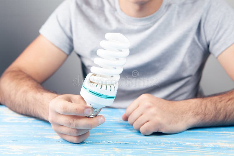 A Man Holding a Modern Light Bulb Stock Image - Image of efficiency ...