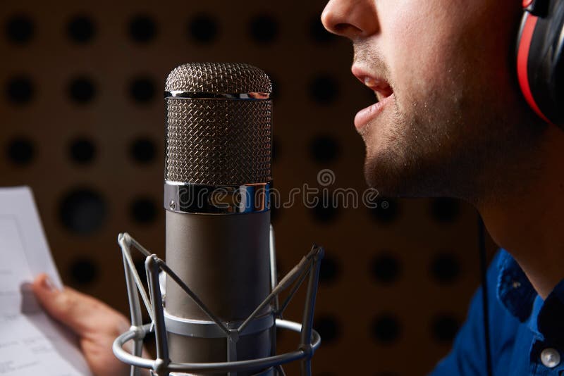 Man Holding Notes and Talking into Studio Microphone Stock Photo ...