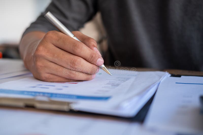 Man Holding Pen To Point in Paperwork, Meeting Concept Stock Photo ...