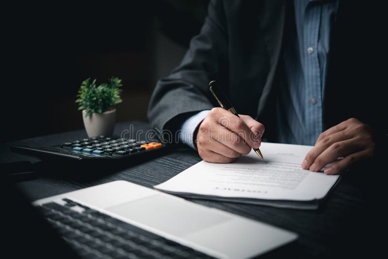 A Man is Holding a Pen, Writing or Checking Documents on a Desk Stock ...