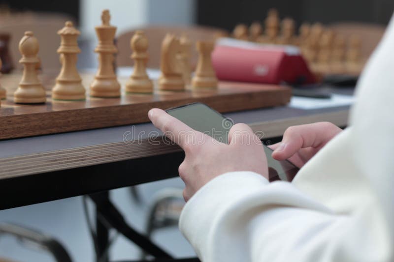 Man Holding a Phone in Their Hands and Playing Chess Stock Photo ...