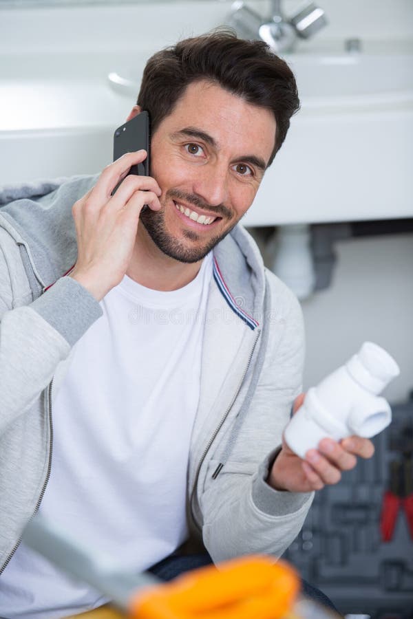 Man Holding Plumbing Fitting and Using Smartphone Stock Image - Image ...