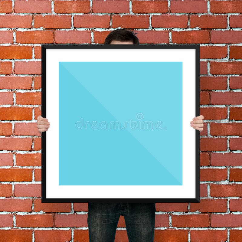 Man Holding Poster Mockup Template with Frame on Brick Background Stock ...