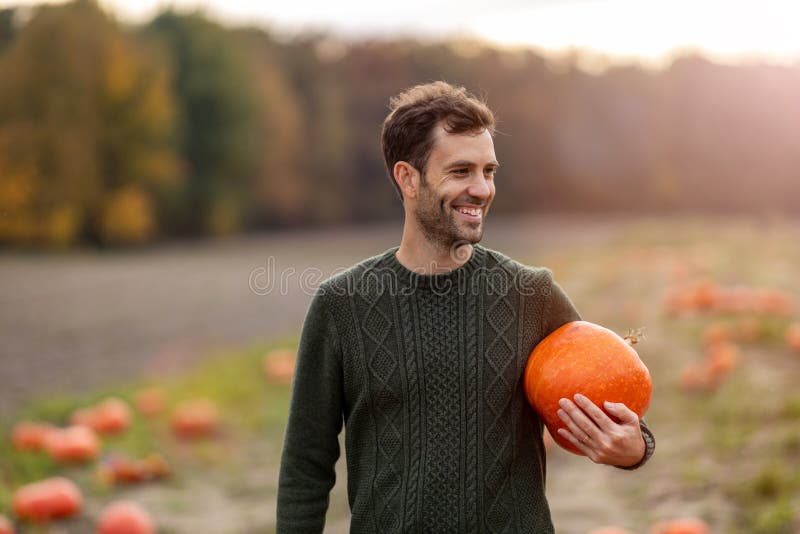 Man Holding Pumpkin in Pumpkin Patch Field Stock Photo - Image of ...