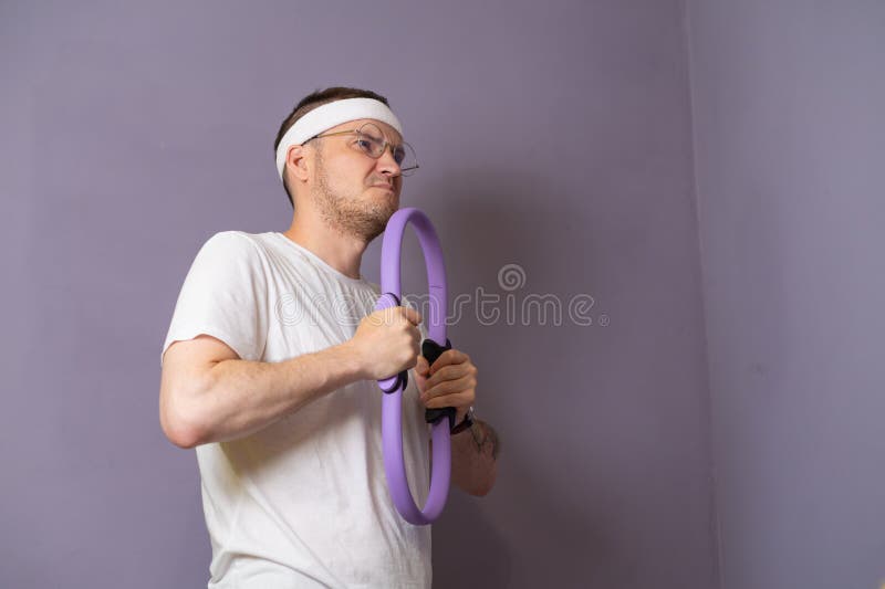 Man Holding Purple Exercise Ring in Front of Purple Wall Stock Image ...