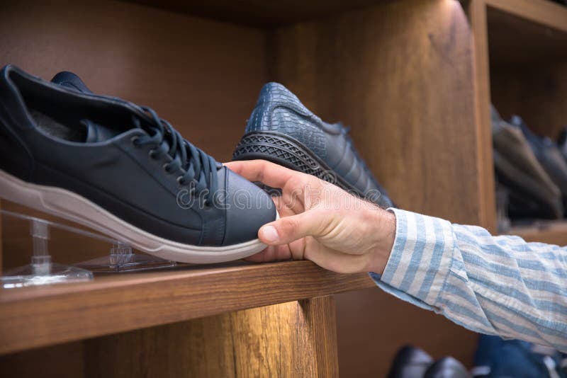 Man holding shoes in shop stock photo. Image of choice - 228160322