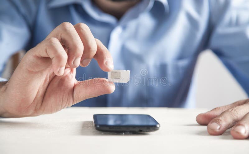 Man Holding Sim Card. Smartphone on the Desk Stock Photo - Image of ...