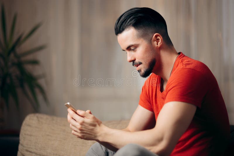 Man Holding Smartphone Relaxing on a Sofa at Home Stock Photo - Image ...