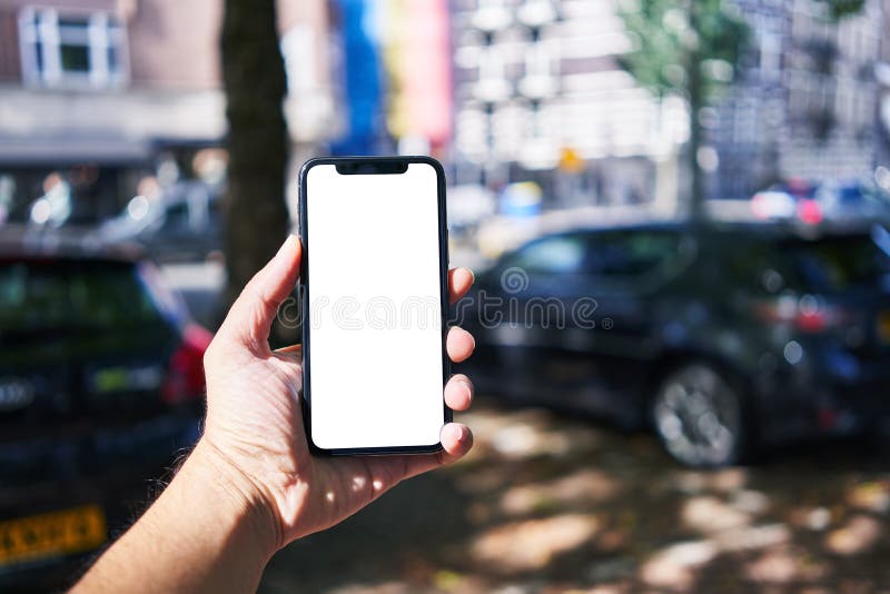 Man Holding Smartphone Showing White Blank Screen at Car Parking Stock ...