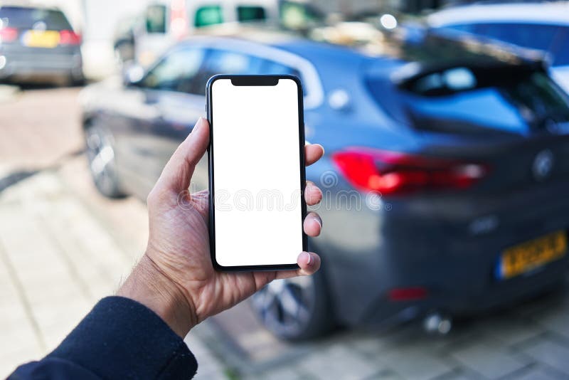 Man Holding Smartphone Showing White Blank Screen at Car Parking Stock ...