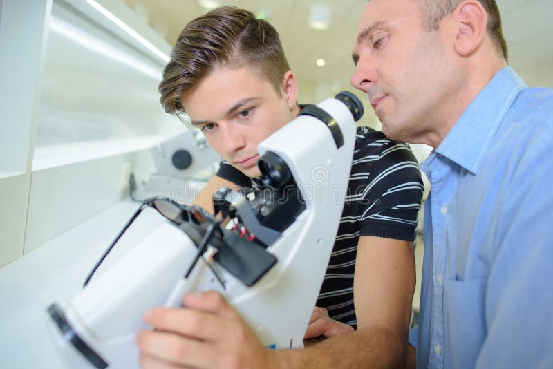 Man Holding Spectacles in Microscope Stock Image - Image of electronic ...