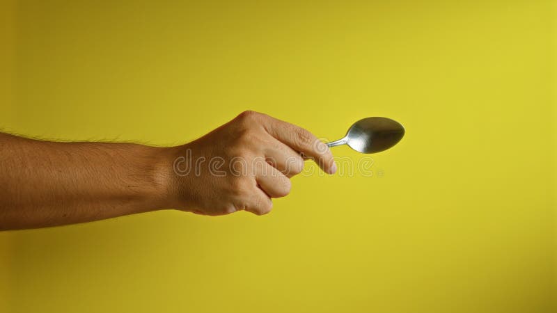 Man Holding Spoon Against Yellow Background Using Hand and Fingers ...