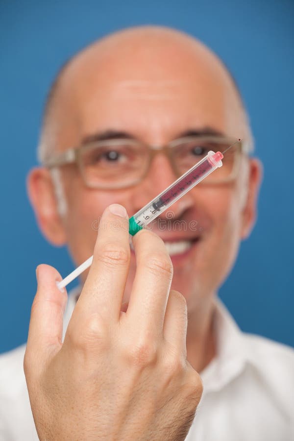 Man Holding a Syringe Up Close Stock Photo - Image of eyeglasses, blue ...