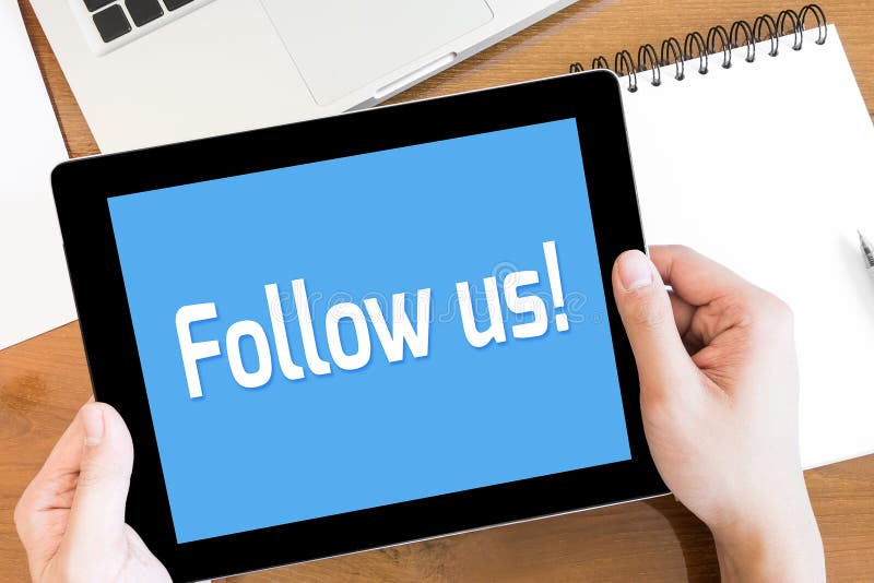Man is Holding Tablet with Display Follow Us Text on the Screen. Social ...