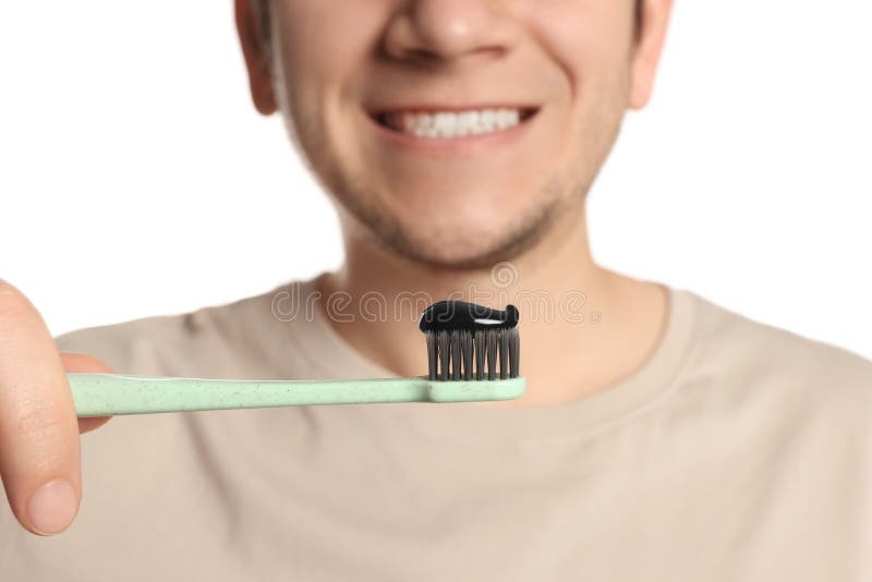 Man Holding Toothbrush with Charcoal Toothpaste on White Background ...