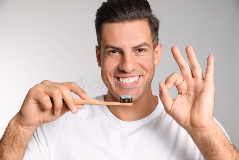 Man Holding Toothbrush with Paste on Light Background Stock Photo ...