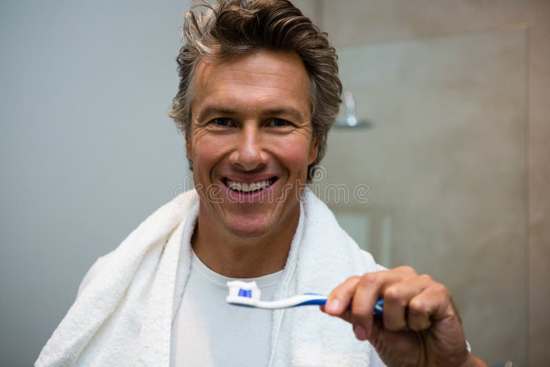 Man Holding Toothbrush with Toothpaste in Bathroom Stock Image - Image ...