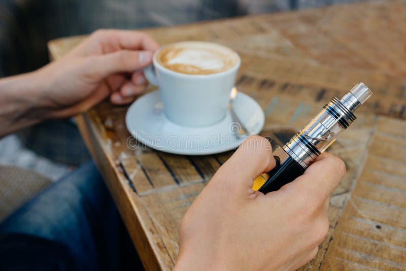 Man Holding Vape or Electronic Cigarette and Drinking Coffee Stock ...