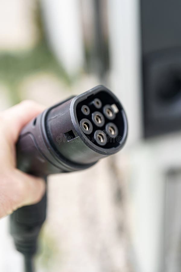 A Man Holds a Car S Electric Charging Cable in His Hand. Stock Image ...