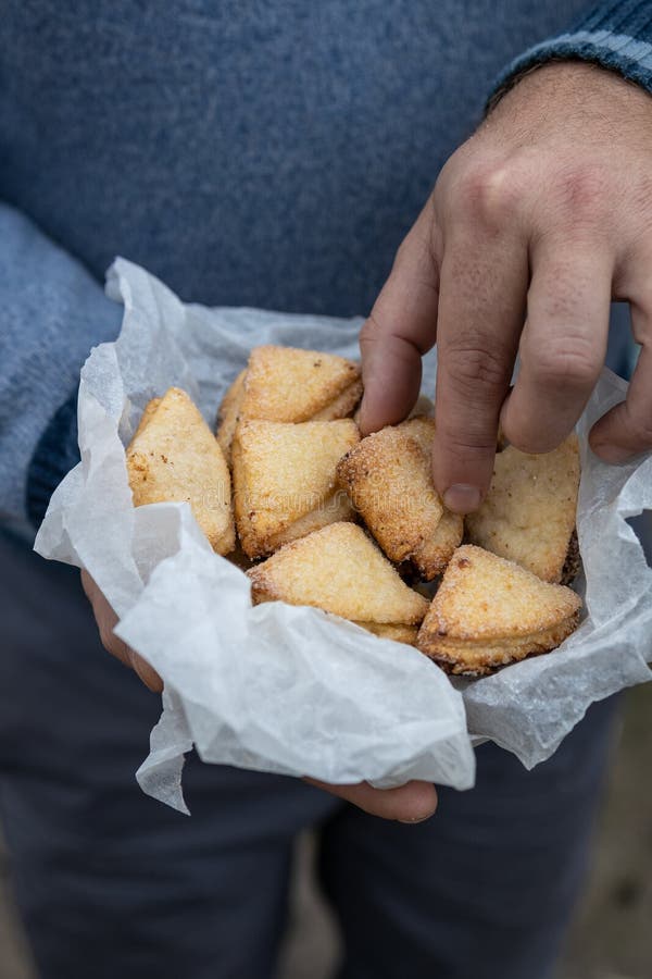 Man Holds Curd Shortbread Cookies in Triangles in White Parchment Paper ...