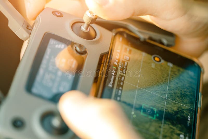 A Man Holds a Drone Remote Control in His Hands, Controlling the Drone ...
