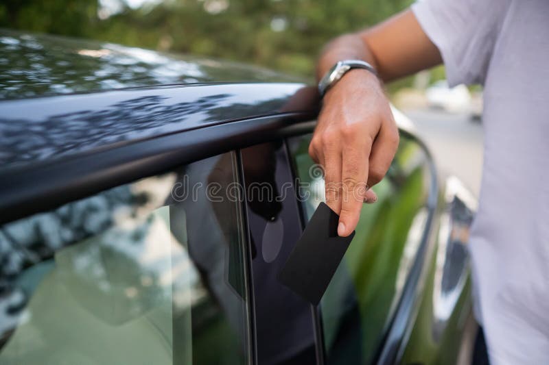 A Man Holds an Electronic Key Card from a Black Electric Car. Stock ...