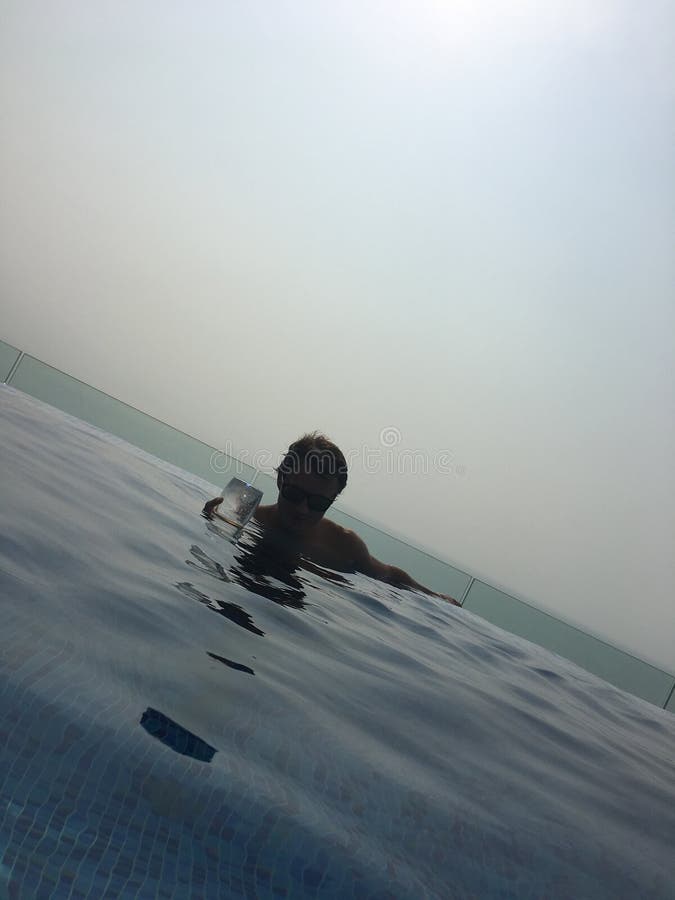 A Man Holds a Glass Up in a Infinity Pool Stock Photo - Image of ...