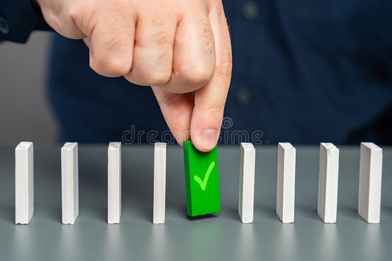 A Man Holds a Green Domino with a Check Mark. Stock Image - Image of ...