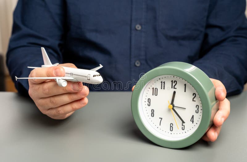 A Man Holds a Passenger Plane and a Clock. Flight Time Stock Image ...