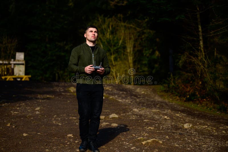 A Man Holds a Remote Control and Controls the Flight of a Drone. Stock ...