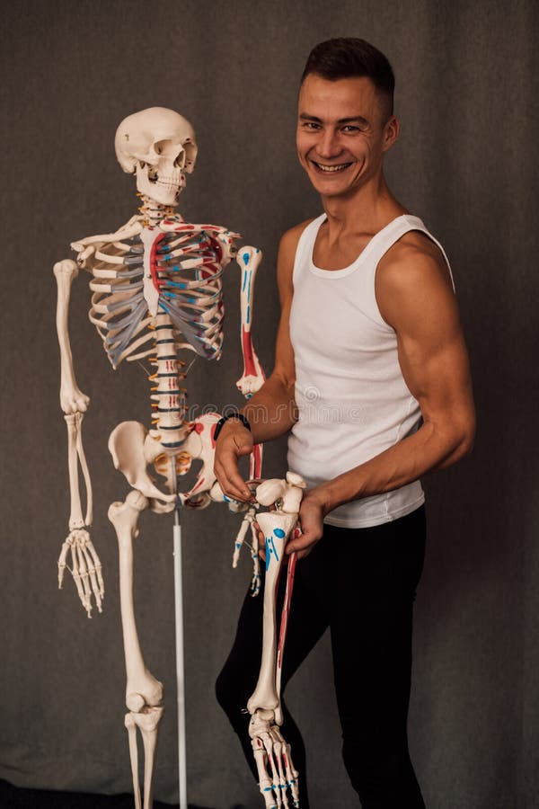 A Man Holds a Skeleton Leg in His Hands and Points a Finger at it Stock ...