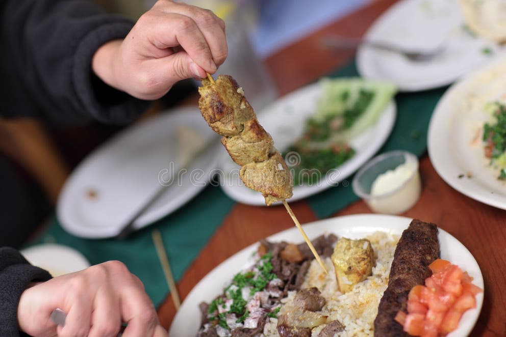 Man holds skewer of kebab stock image. Image of holding - 19351945