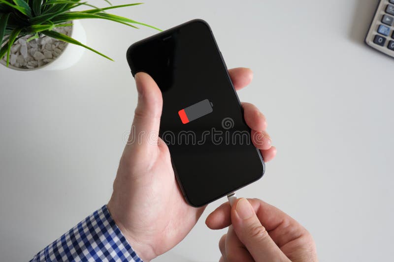 A Man Holds a Smartphone in His Hand, Connected Cable To a Charger from ...