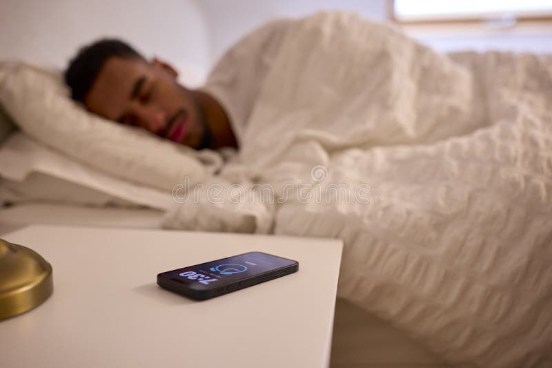 Man at Home Asleep in Bed with Alarm Going Off on Mobile Phone Stock ...