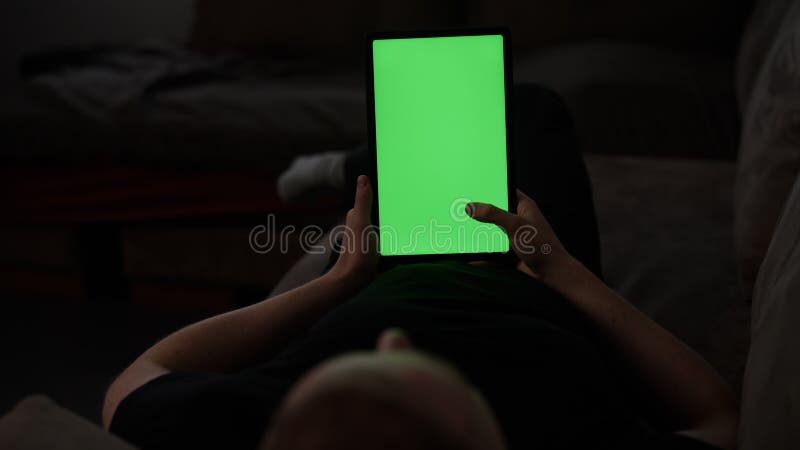 Man at Home Lying on a Couch with Tablet Pc with Green Screen Stock ... Man at Home Lying on a Couch with Tablet Pc with Green Screen Stock ...