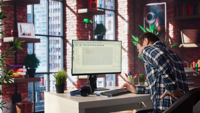 Man At Home Stretching Back While Looking At Ui On Pc Screen Feeling Fatigued Stock Footage