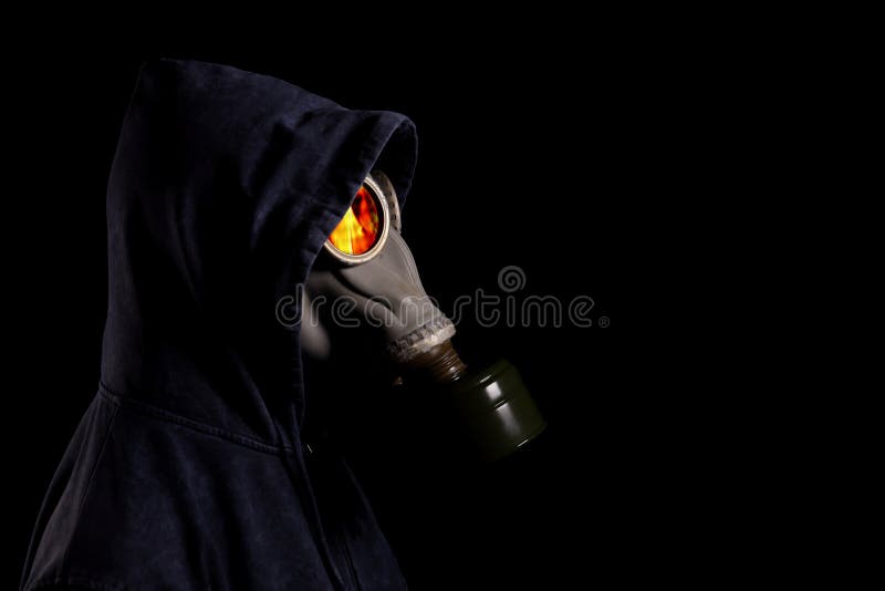 A Man in a Hood in a Gas Mask with a Reflection of Fire in the Glasses ...