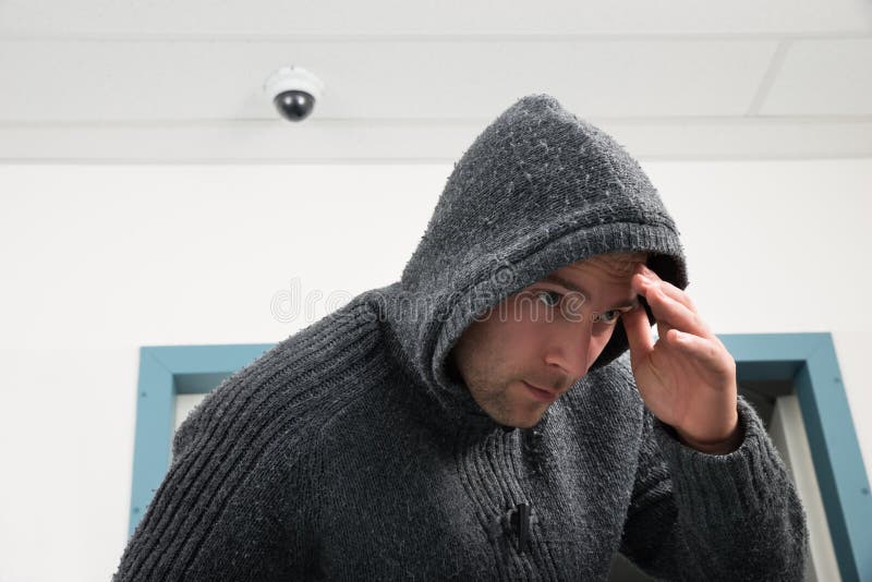 Man in Hooded Sweatshirt with Cctv Camera Behind Stock Image - Image of ...