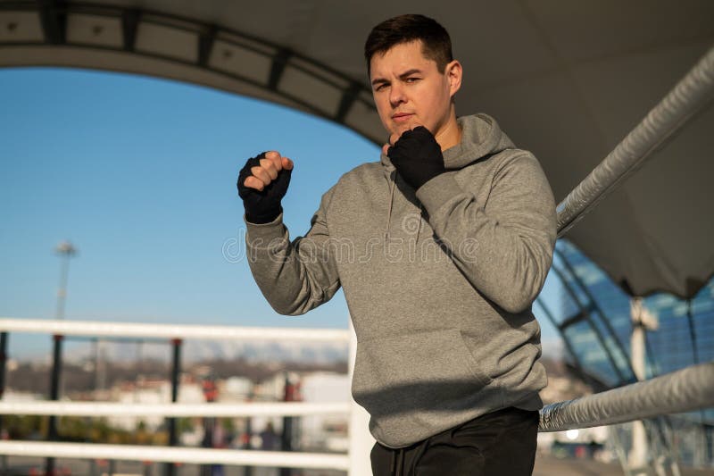 A Man in a Hoody Trains in Boxing at the Stadium. Stock Photo - Image ...