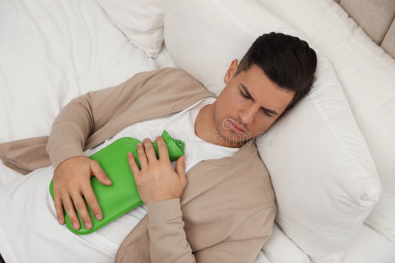 Man with Hot Water Bottle Sleeping on Bed Stock Photo - Image of chest ...