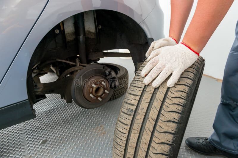 Man with a Huge Wheel Mechanic Near Car Stock Image - Image of replace ...