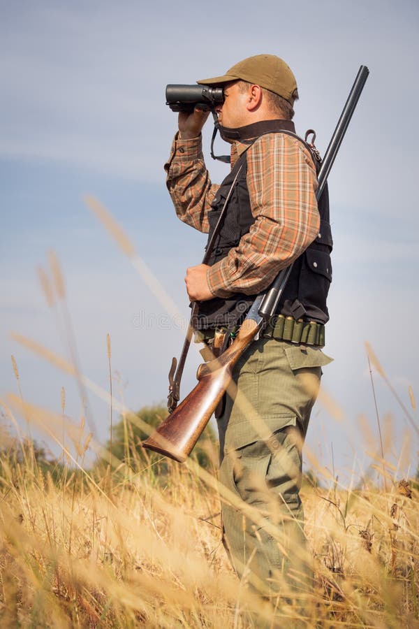 Man Hunter with Shotgun Looking through Binoculars in Forest Stock ...