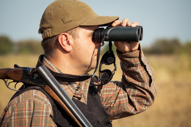 Man Hunter with Shotgun Looking through Binoculars in Forest Stock ...