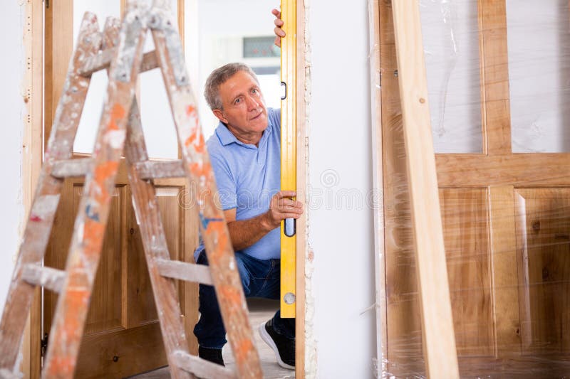Man Independently Measures Deviations from Given Vertical Wall of Door ...