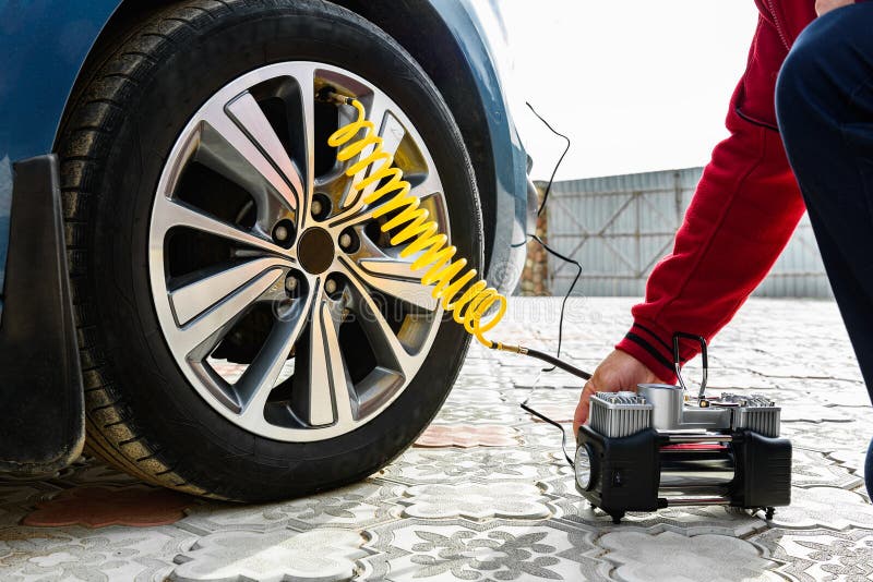 Man Inflating Car Wheel Using Automobile Compressor. Stock Image ...