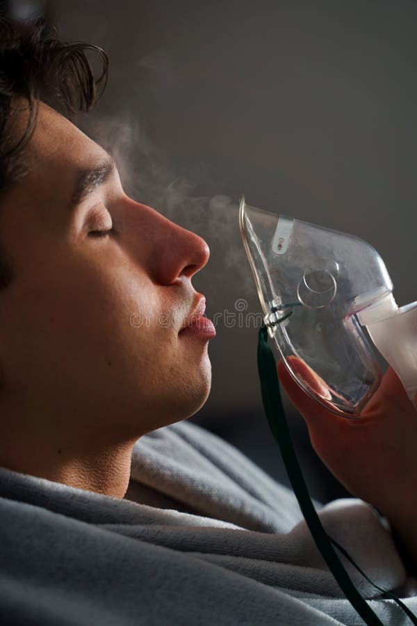 Man Inhaling through Oxygen Mask for Cough Treatment. Using Compressor ...